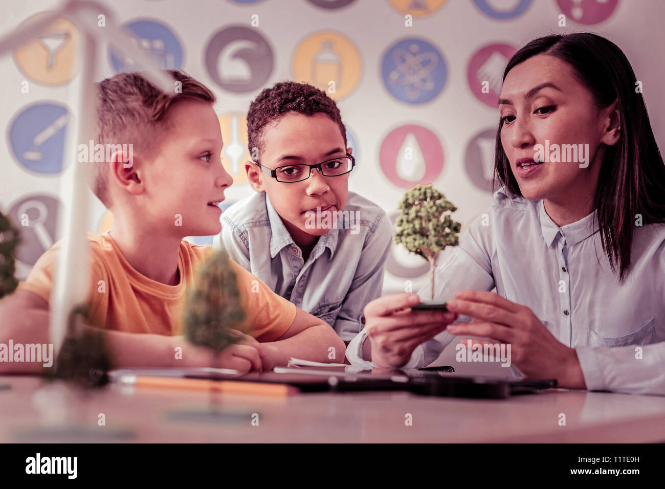 Long-haired female teacher carrying unreal tree during lection Stock ...