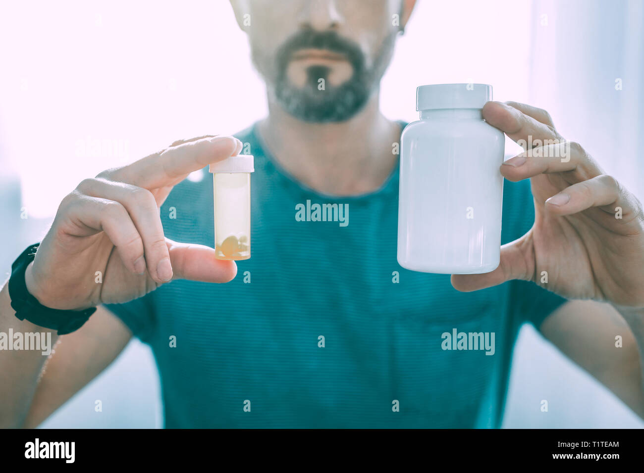 Serious man showing two different types of pills Stock Photo - Alamy