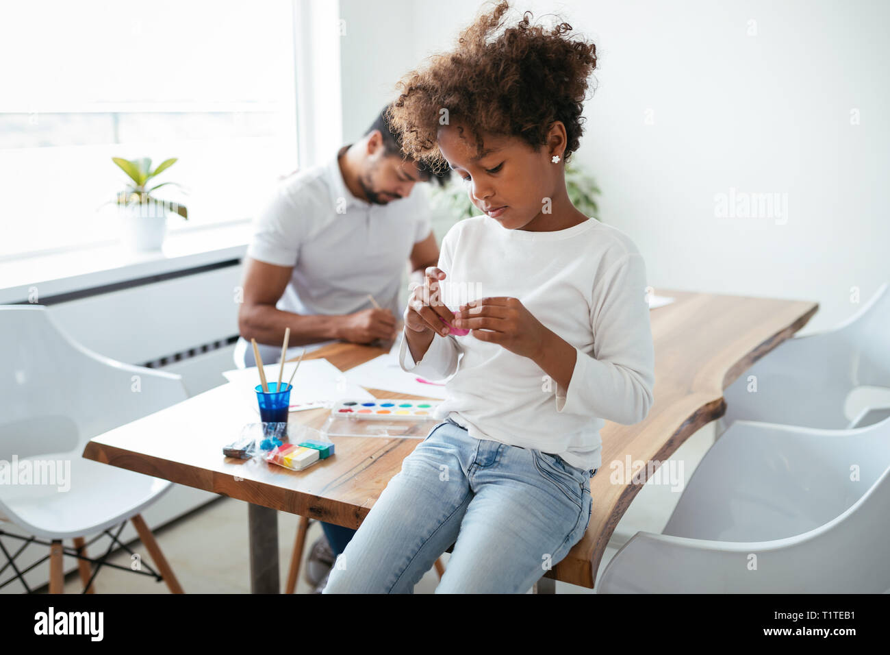 Mother and father drawing together with their child Stock Photo - Alamy