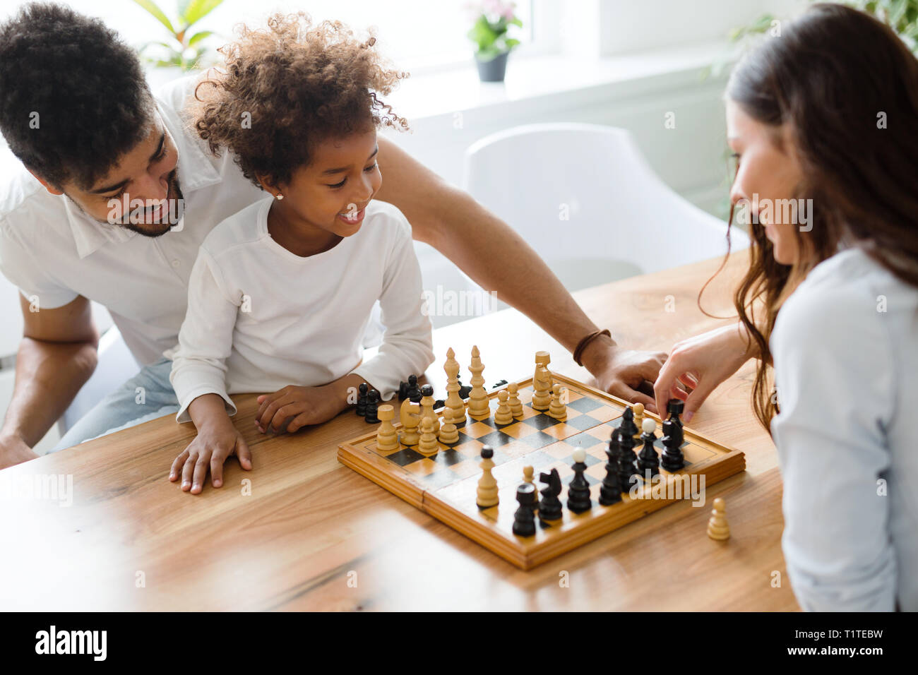 Happy family playing chess together at home Stock Photo - Alamy