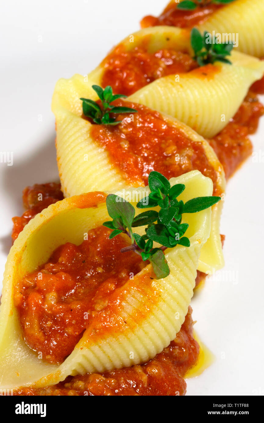 Italian food: Shell-shaped pasta with bolognese ragu and aromatic herbs ...
