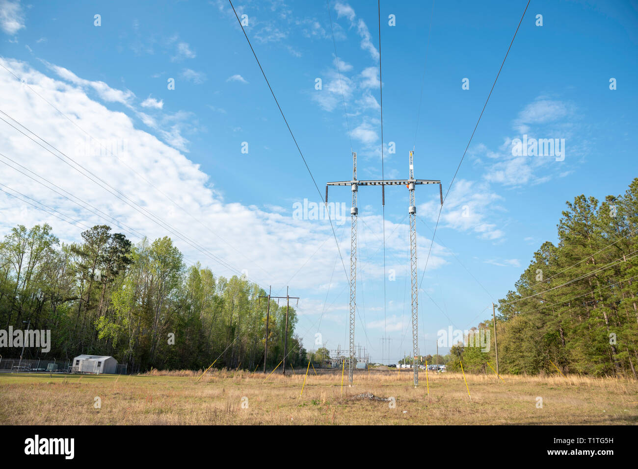 A tall electrical pole hoisting several lines of live power over ...