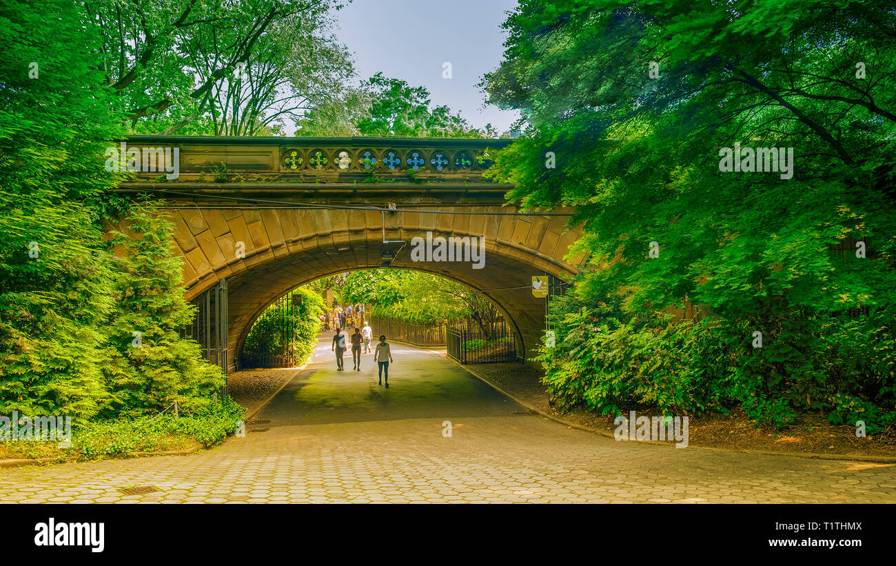 New York City, USA, May 2018, pedestrians under a stone bridge of ...