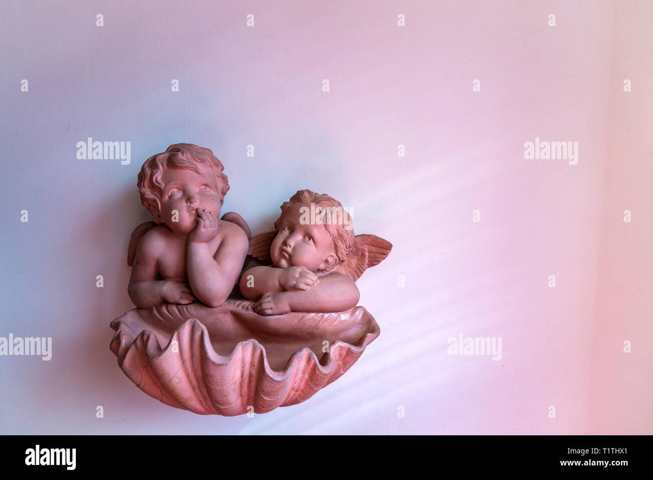 Two pretty Cherubs leaning on their arms and looking out as they lean ...