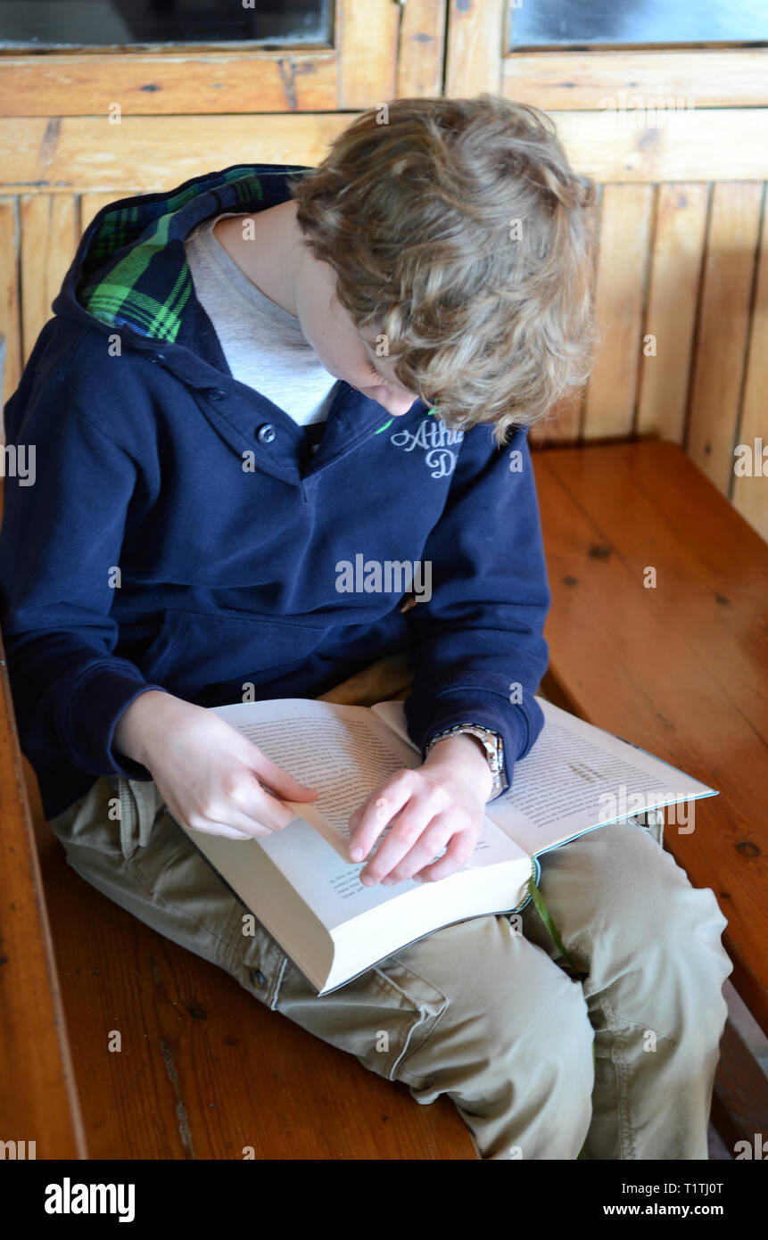 Caucasian teen boy reading book hi-res stock photography and images - Alamy