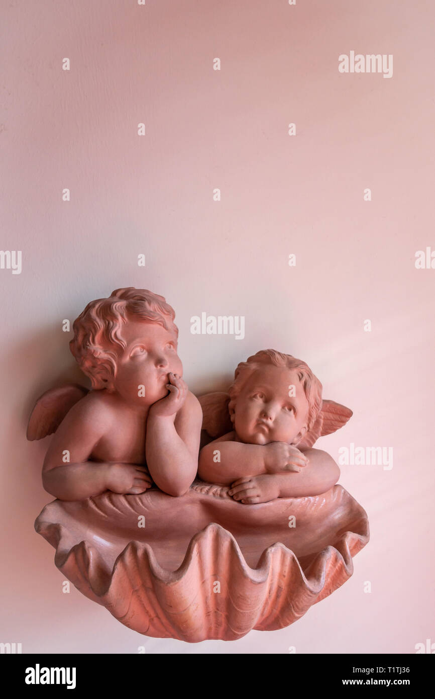Two pretty Cherubs leaning on their arms and looking out as they lean ...