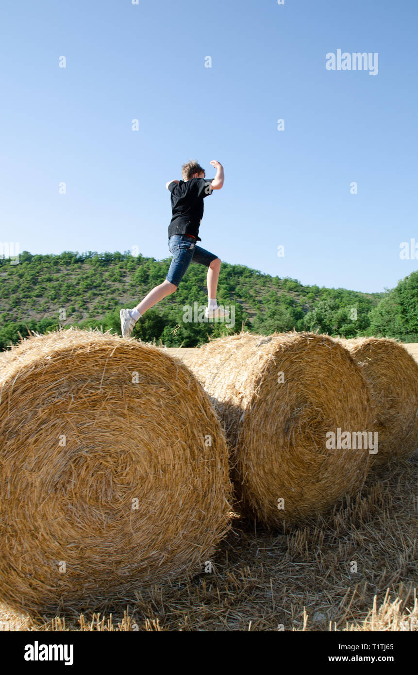 Child jumping on hay in hi-res stock photography and images - Alamy