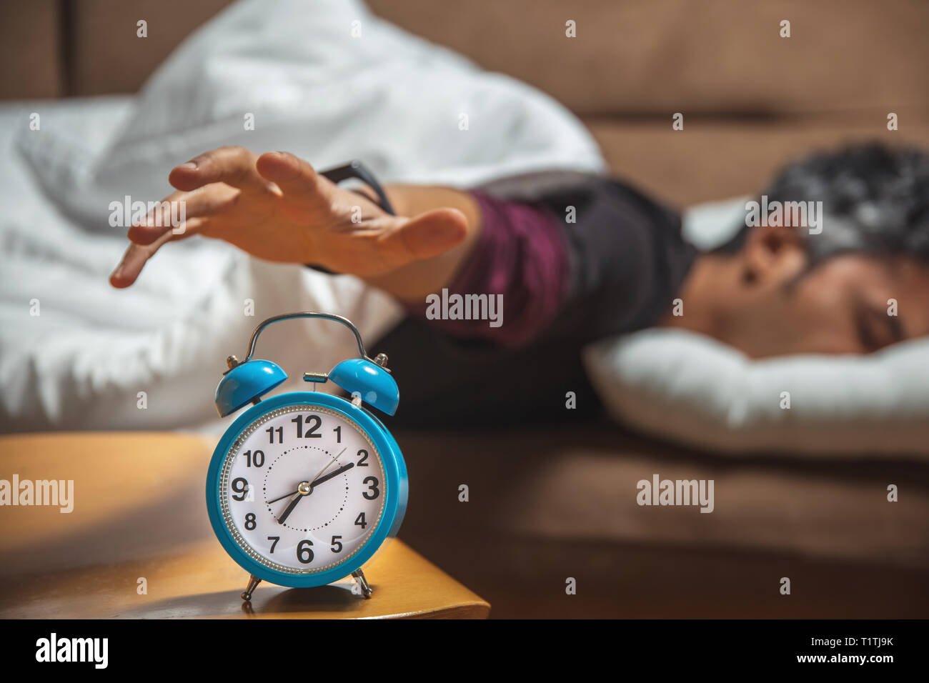 close up view of a sleepy guy trying to snooze a vintage clock Stock ...