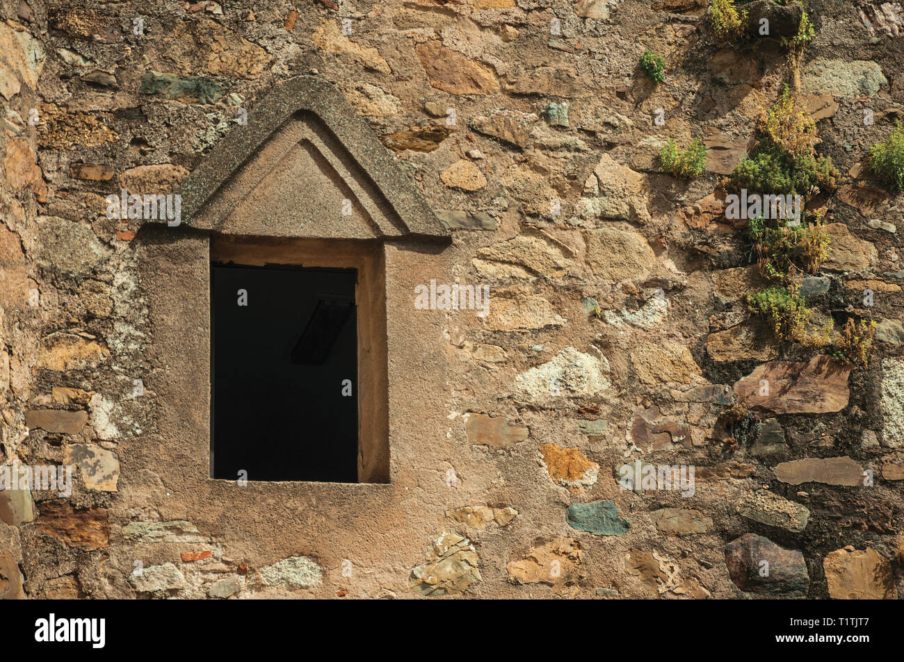 Open window on an ancient stone wall at Caceres. A charming town with a ...