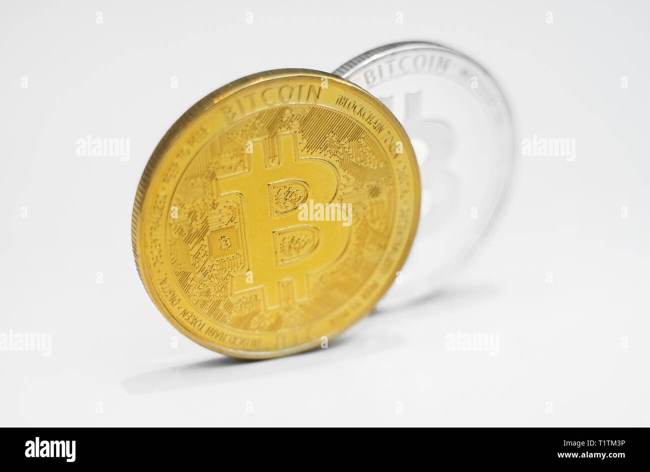 Physical version of silver and golden bitcoins on white background ...