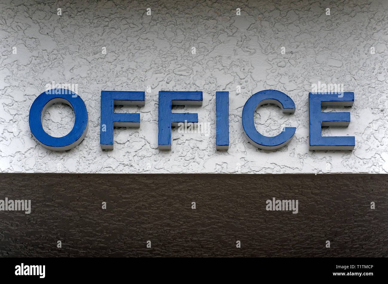Blue office sign on a grey plaster wall background Stock Photo - Alamy
