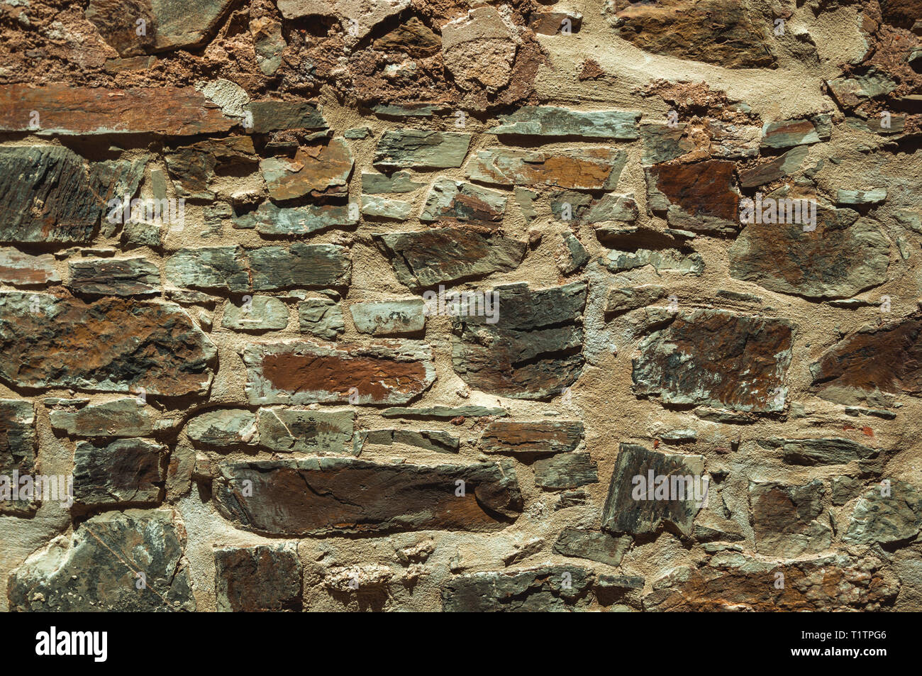 Wall made of rough stones forming a singular background at Caceres. A ...