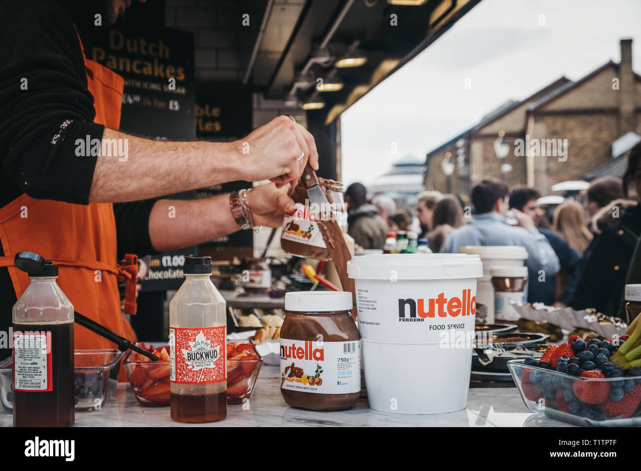 London, UK - March 23,2019: Staff cooking Dutch pancakes at a stall ...