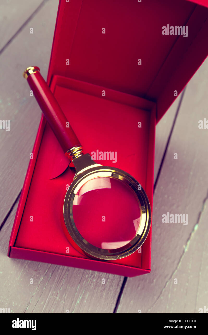 Gift box with magnifying glass Stock Photo - Alamy