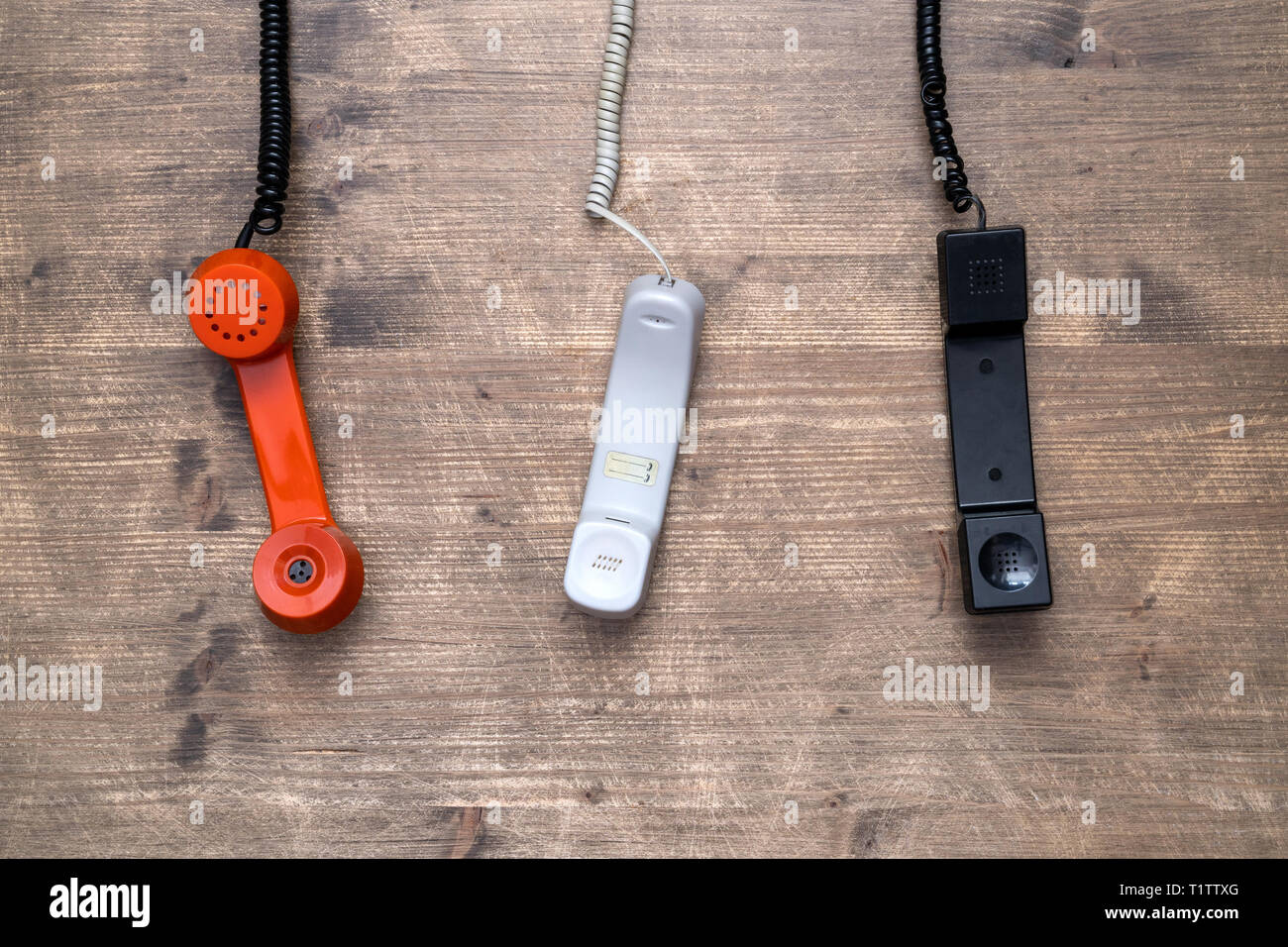 Three old phone handles hanging down on a cord. Urgent business ...