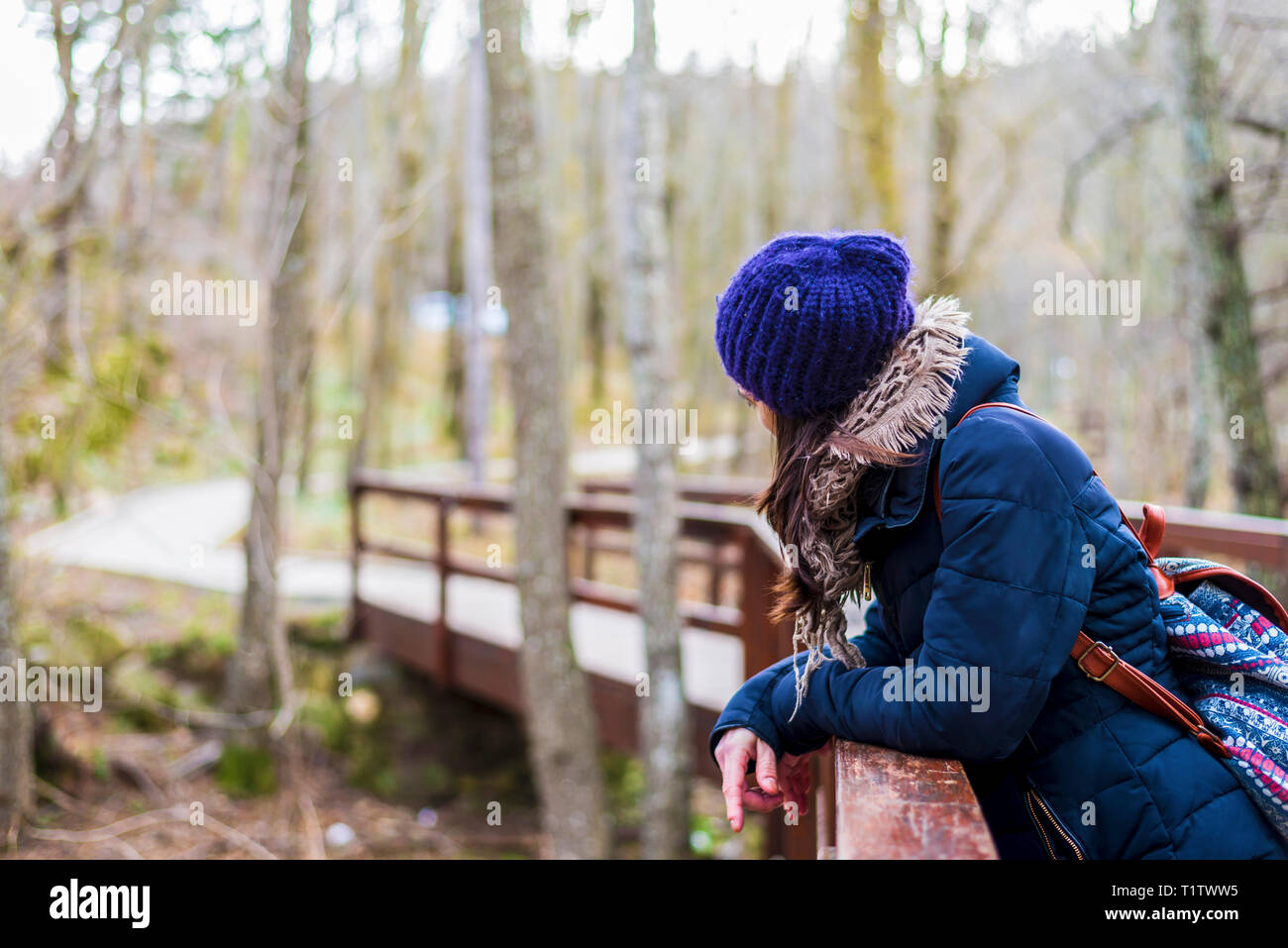 Side view portrait of beautiful girl with backpack standing near old ...