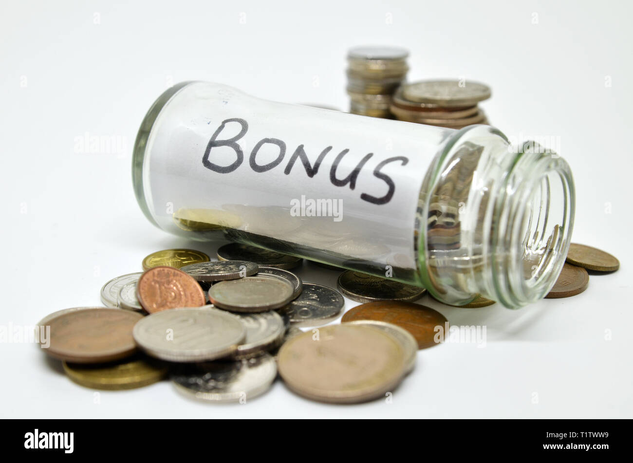 Bonus lable in a glass jar with coins spilling out isolated on white ...