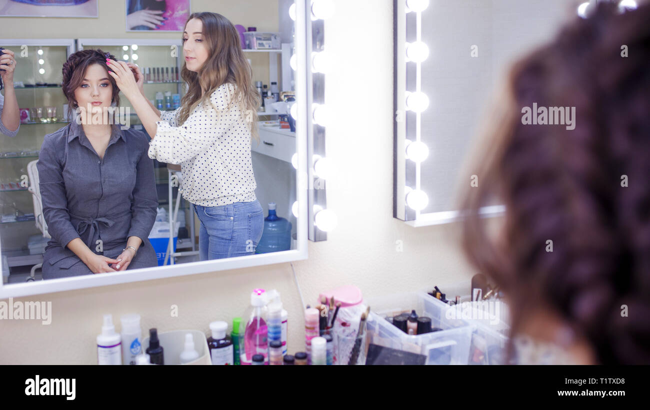 Stylist makeup artist doing makeup and hair in a beauty salon ...