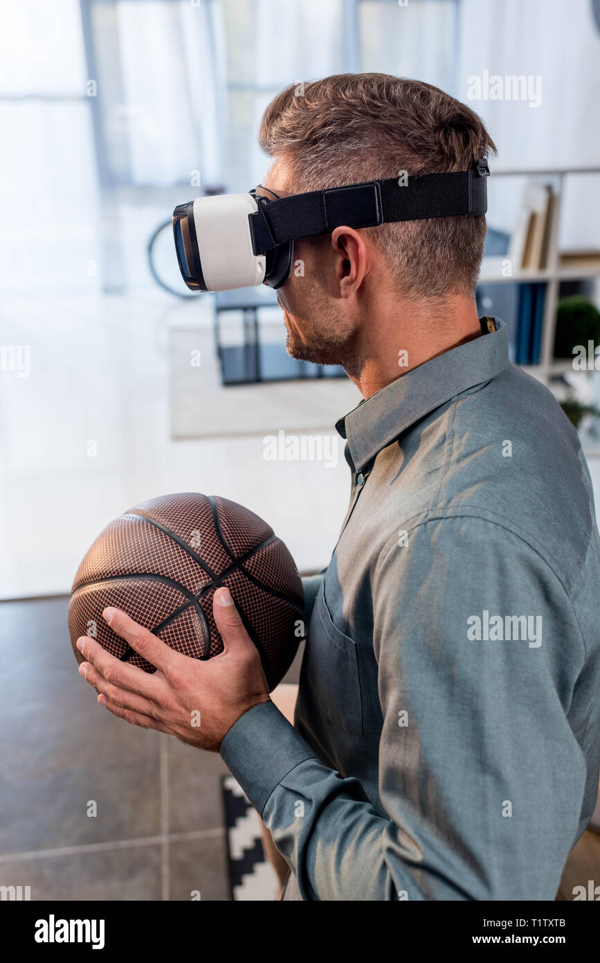 businessman wearing virtual reality headset and holding basketball ...