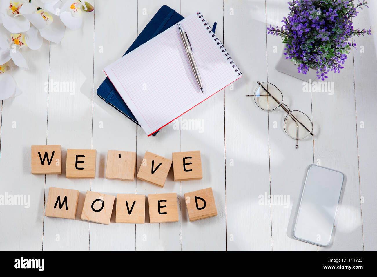 WE HAVE MOVED. Message at at wooden cubes on a desk background ...