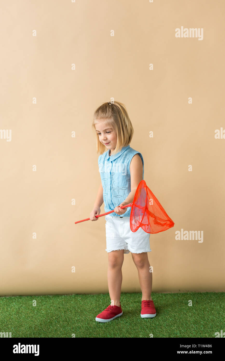 cute kid with red butterfly net on beige background with copy space ...