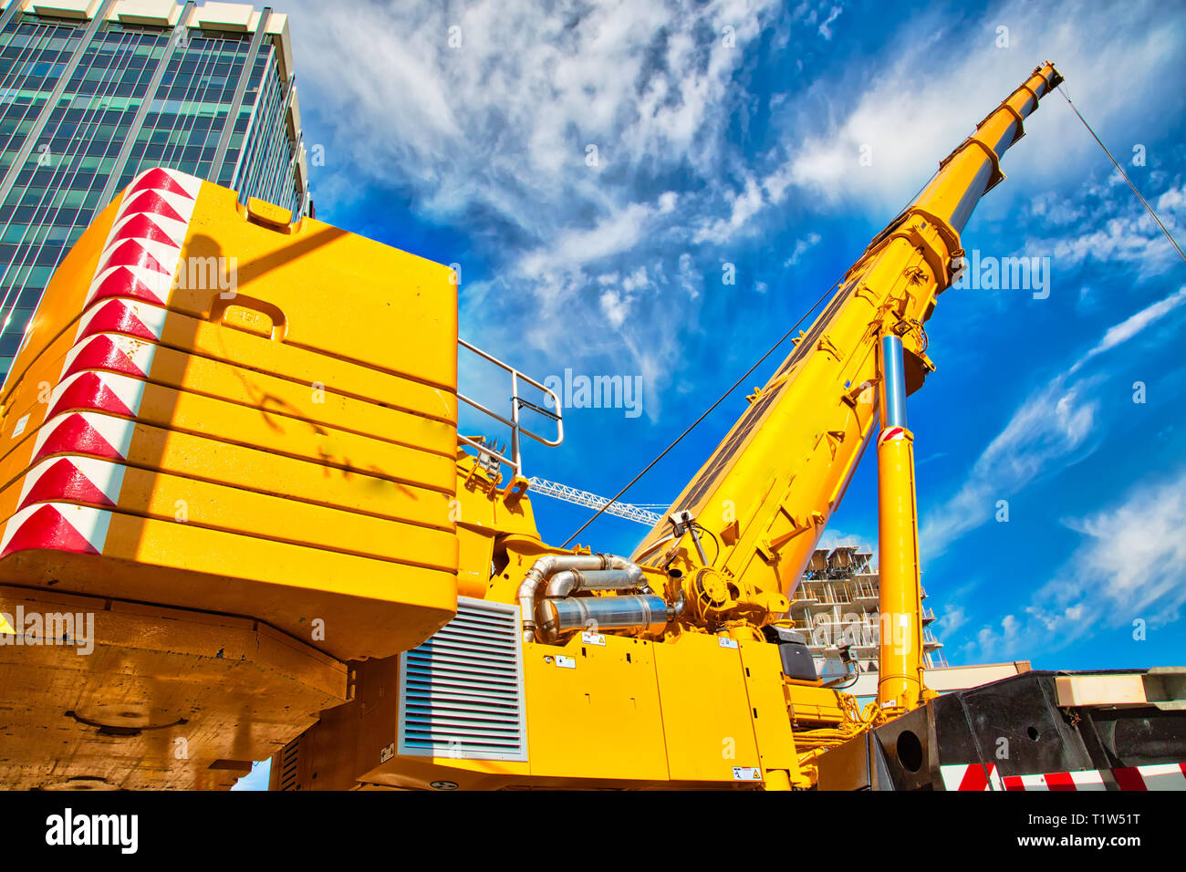 Mobile crane at work at downtown construction site Stock Photo - Alamy