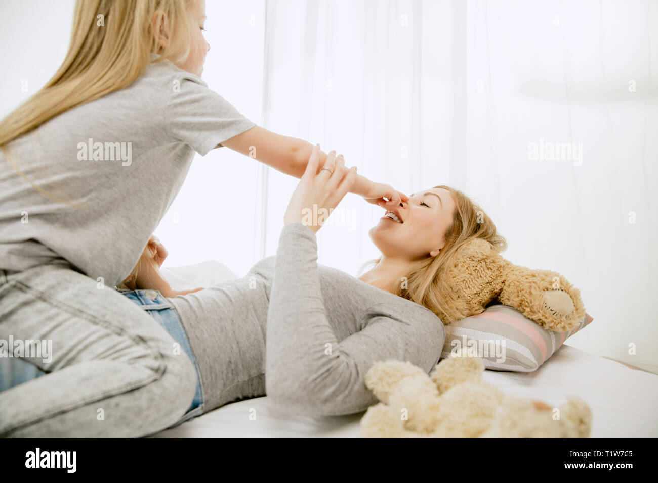 Young mother and her little daughter at home at sunny morning. Soft ...