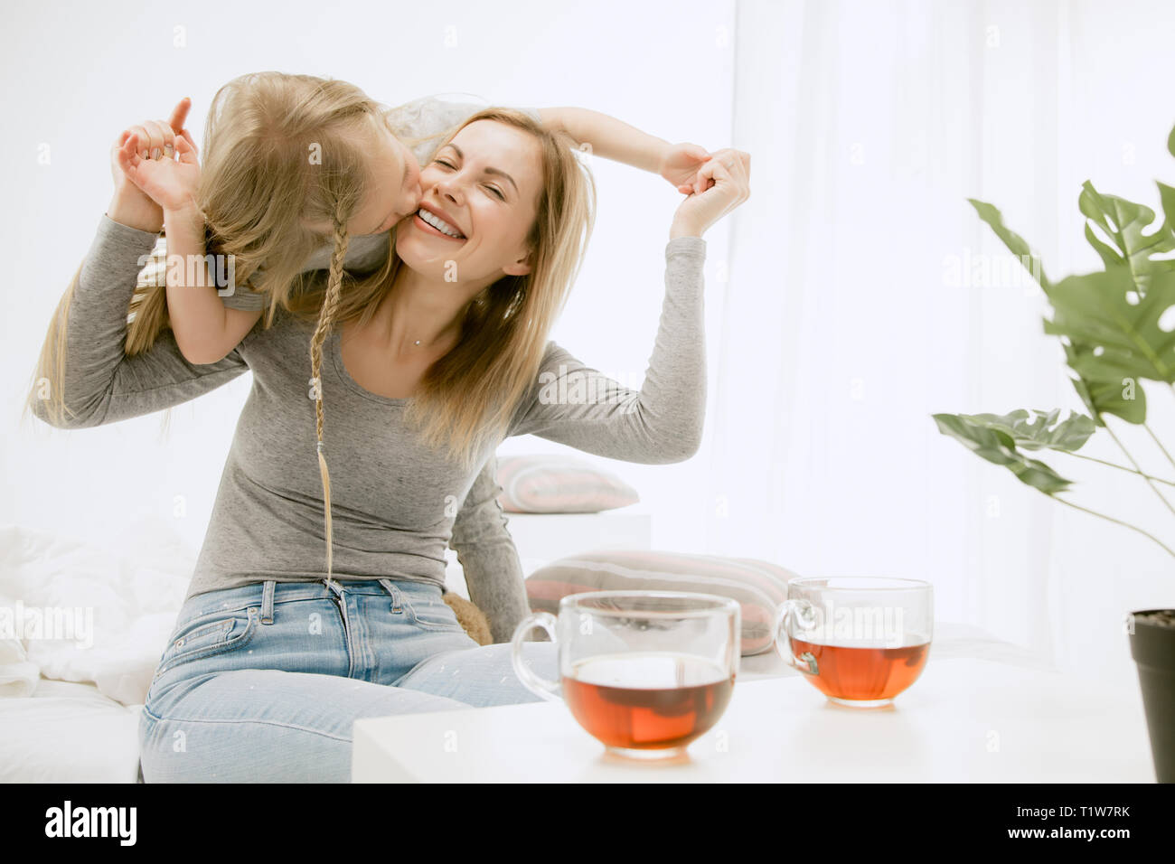 Young mother and her little daughter at home at sunny morning. Soft ...