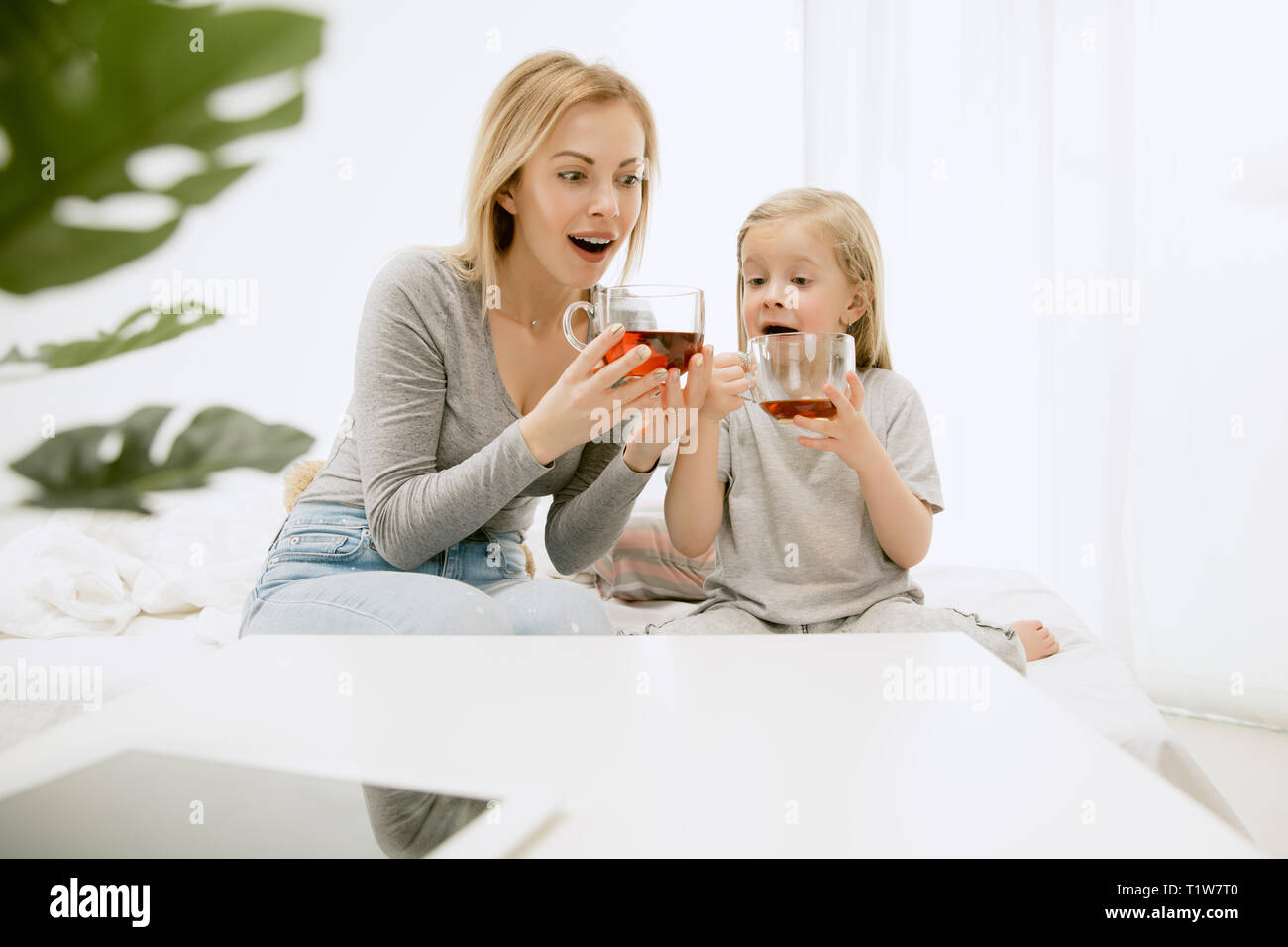 Young mother and her little daughter at home at sunny morning. Soft ...