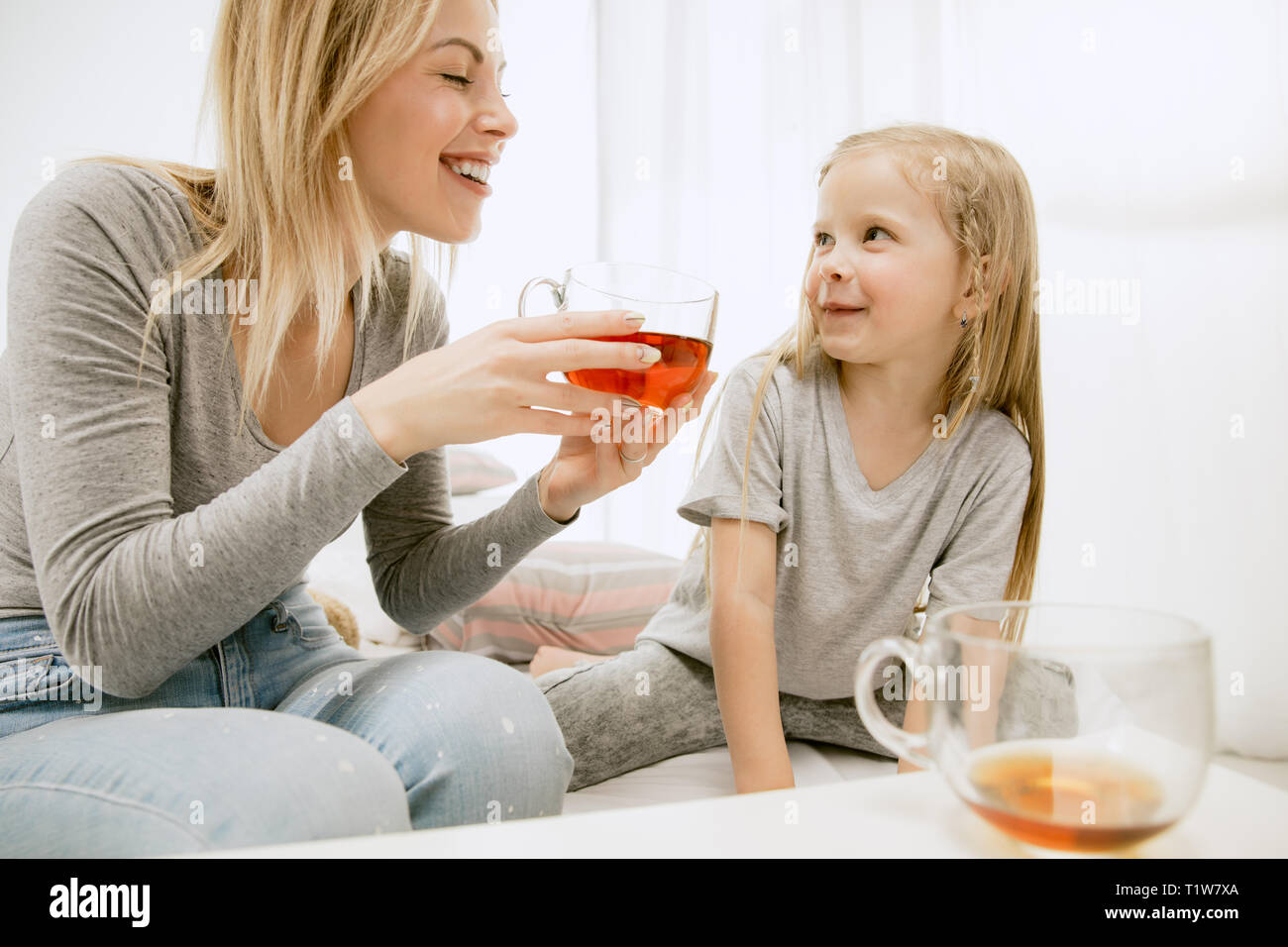 Young mother and her little daughter at home at sunny morning. Soft ...