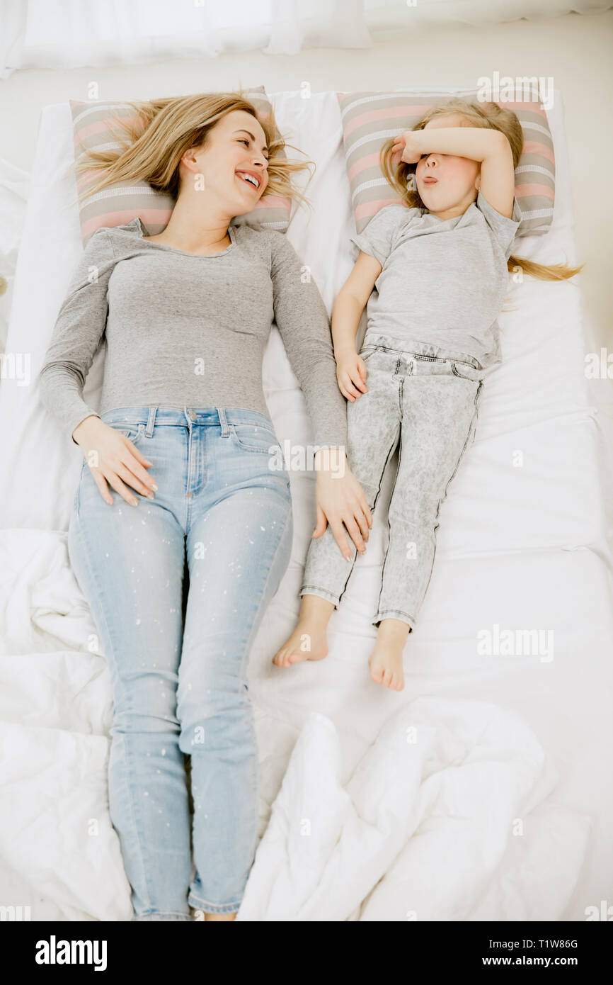 Young mother and her little daughter at home at sunny morning. Soft ...