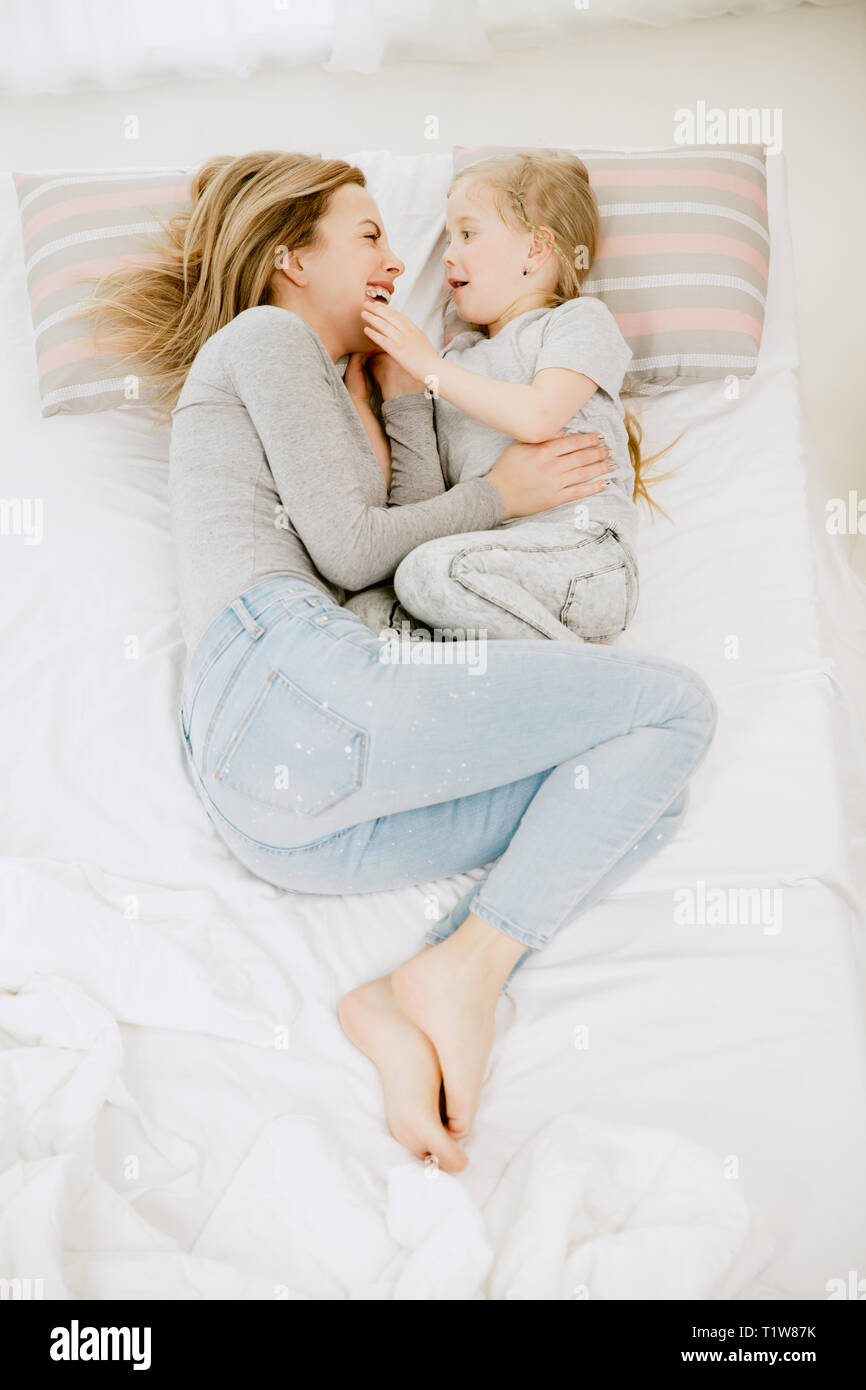 Young mother and her little daughter at home at sunny morning. Soft ...