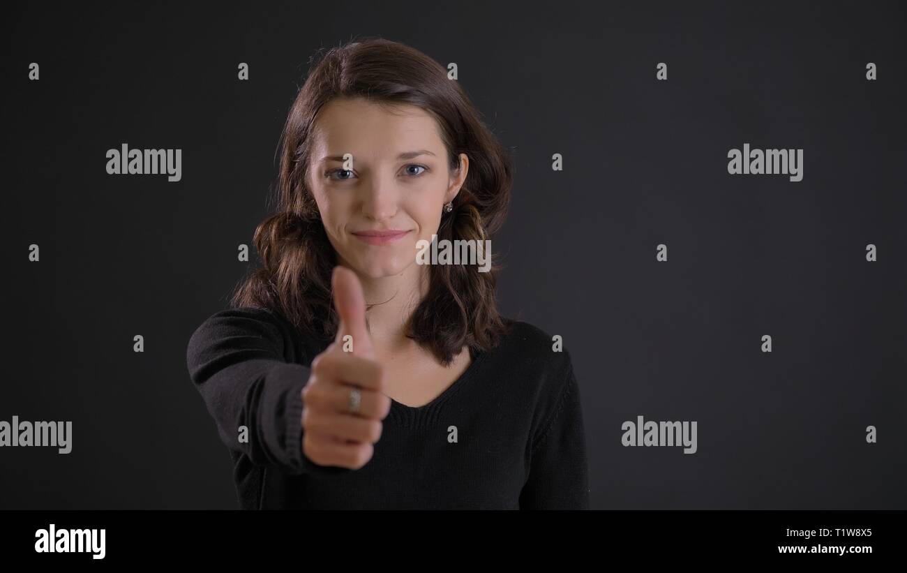 Portrait of cute young brunette woman gesturing finger-up sign ...