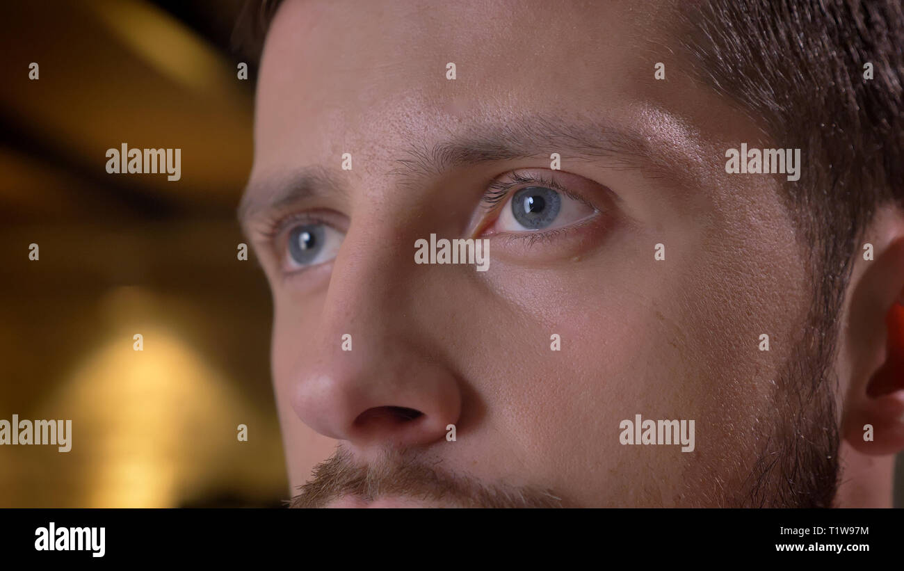 Closeup shoot of adult caucasian bearded male face with eyes looking ...