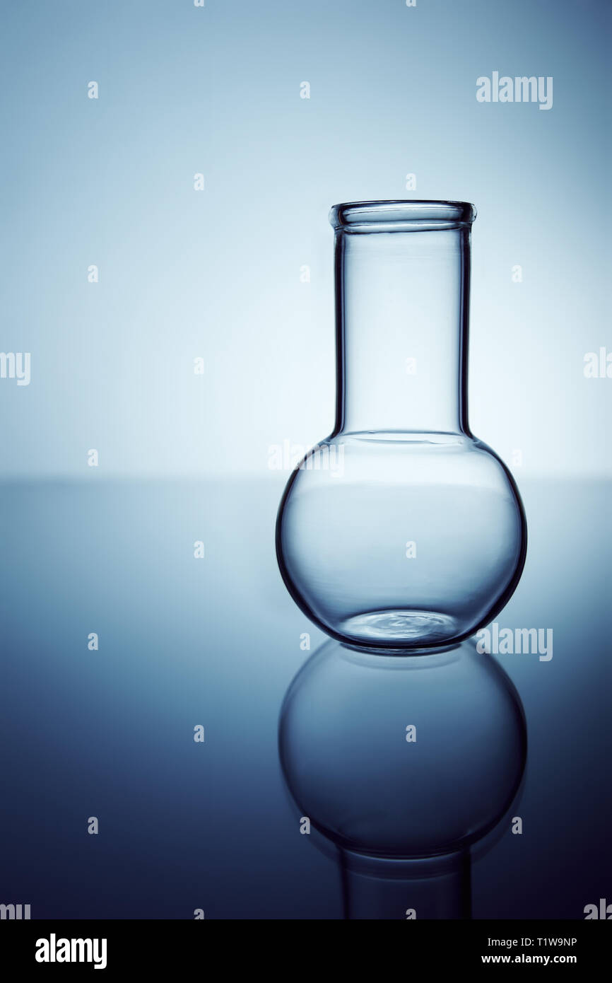 one beaker in backlight, reflection, blue background Stock Photo - Alamy