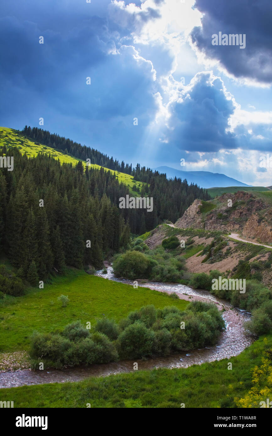 The river winds through the mountains.Sun rays and clouds. Summer time ...