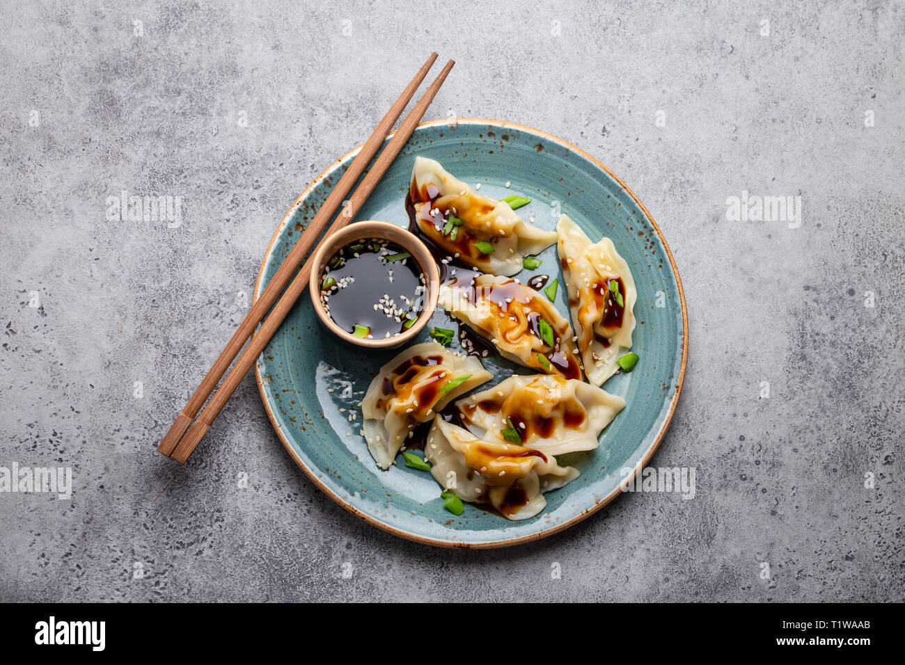Asian dumplings on blue plate Stock Photo - Alamy