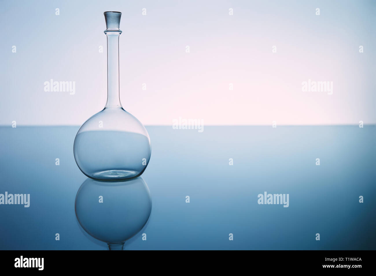 one beaker in backlight, reflection, blue background Stock Photo - Alamy
