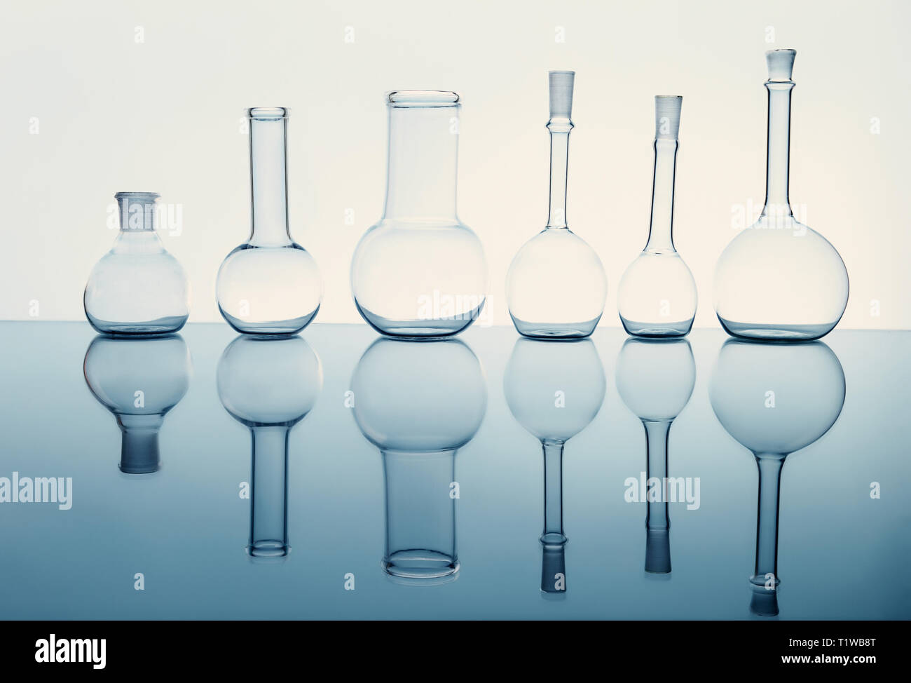 many of the beakers are in a row in the backlight, the reflection, the ...