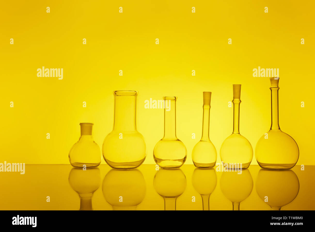 many of the beakers are in a row in the backlight, the reflection, the ...