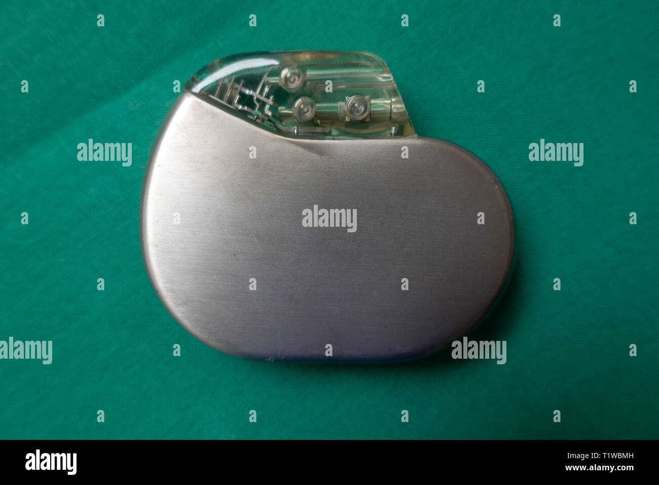 an explanted pacemaker on a green surgical drape Stock Photo - Alamy