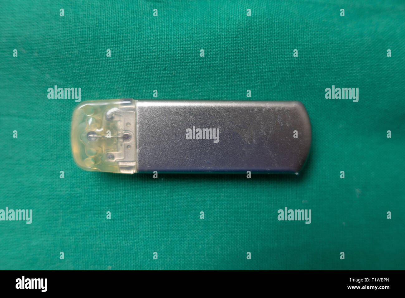 an explanted event recorder on a green surgical drape Stock Photo - Alamy