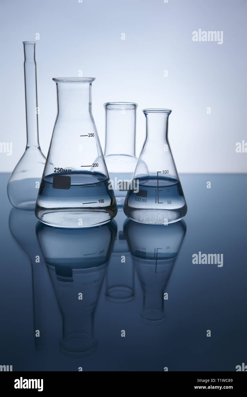 many beakers in the backlight, reflection, blue background Stock Photo ...