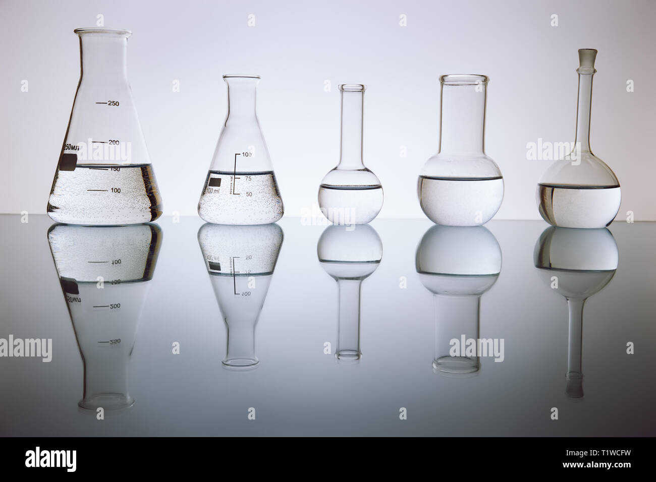 many of the beakers are in a row in the backlight, the reflection, the ...