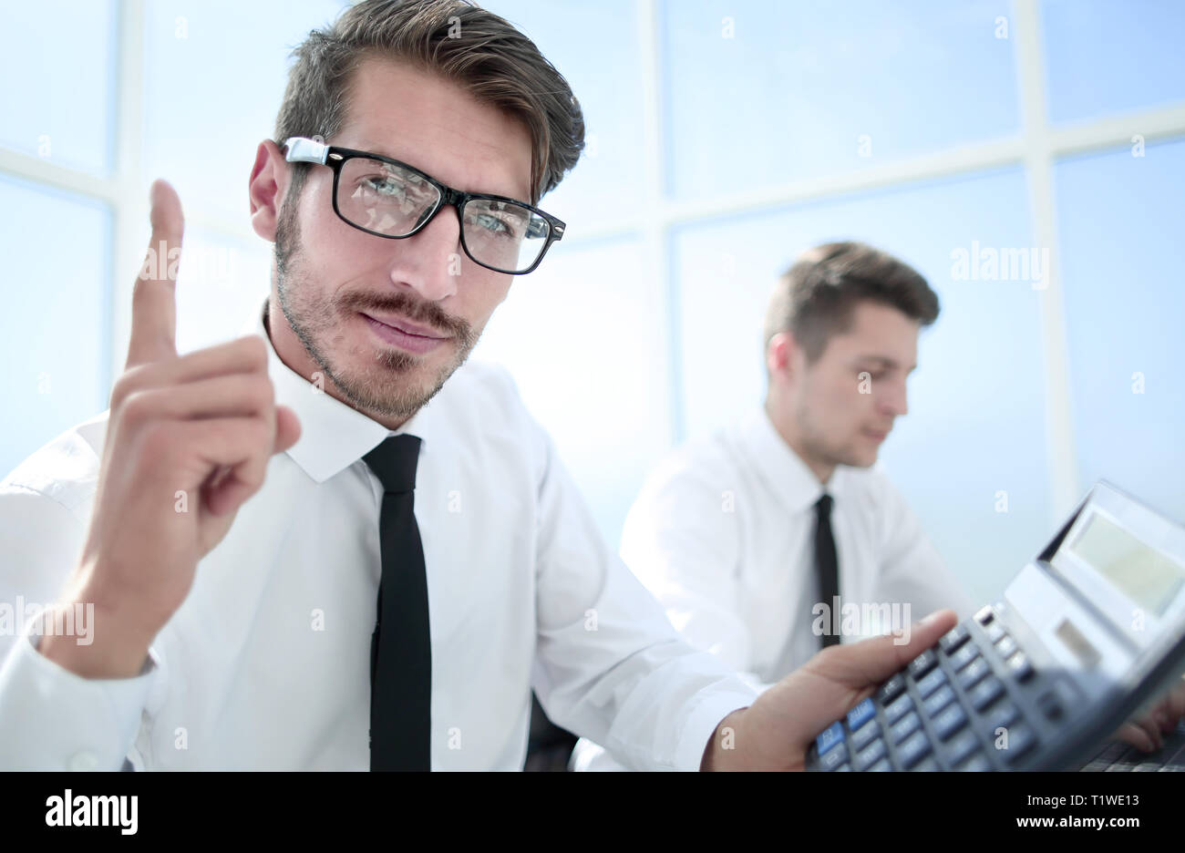 young accountant holding a thumb up and smiling Stock Photo - Alamy