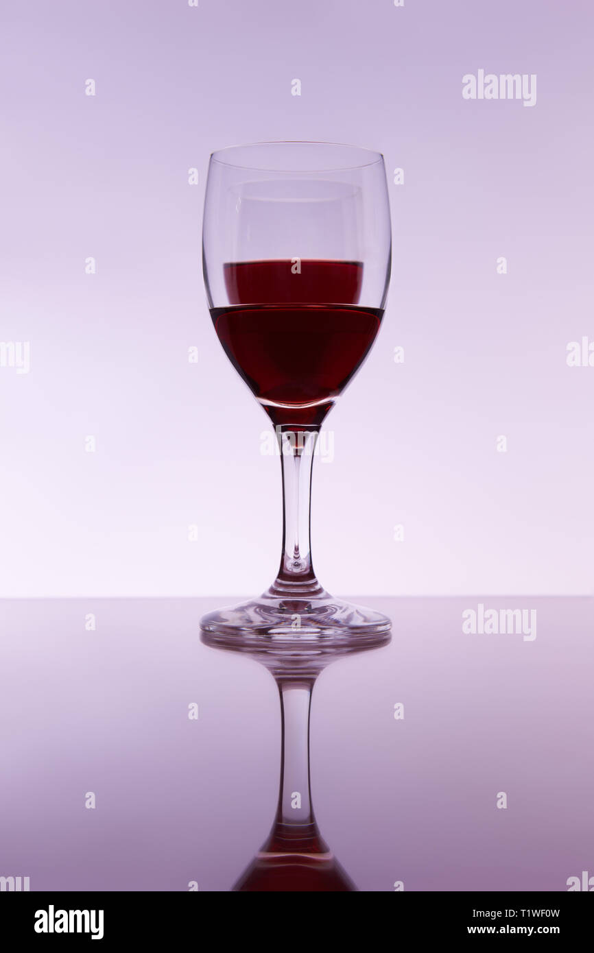 wine glasses a reflection on a light red background, backlighting Stock ...