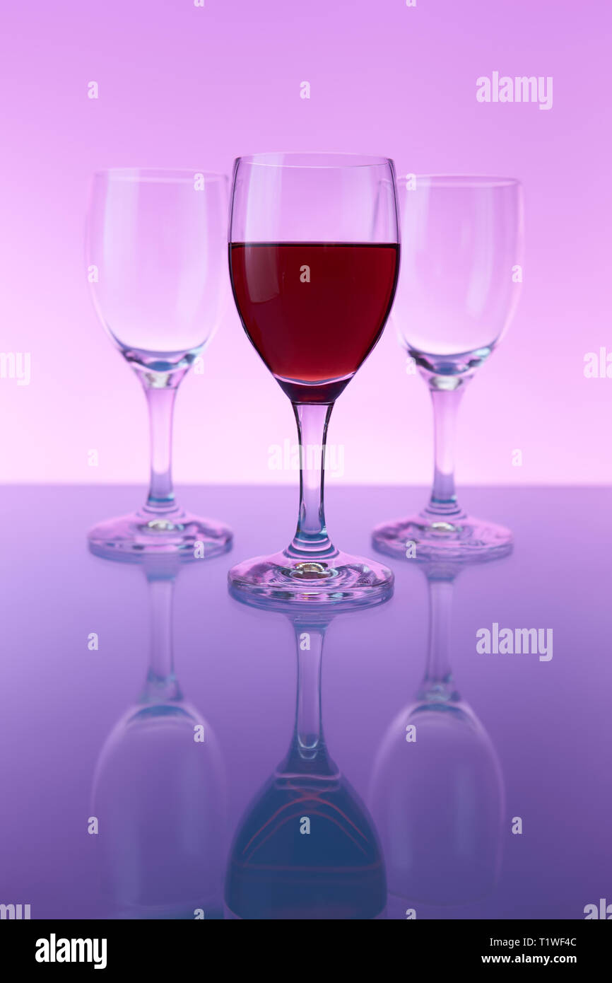 wine glasses a reflection on a light violet background, backlighting ...