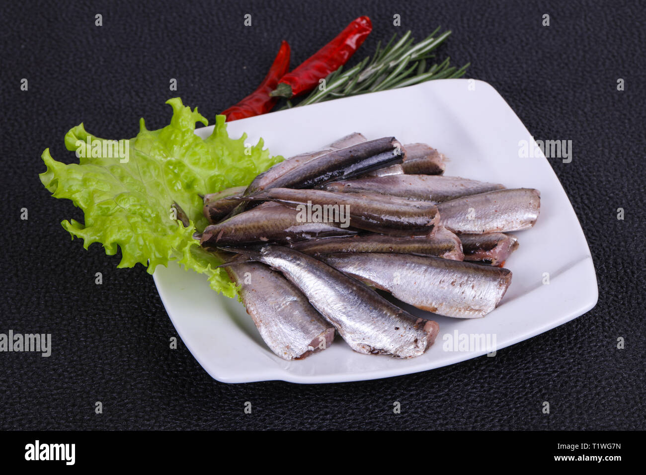 Anchovy fish snack in the bowl served salad leaves and rosemary Stock ...