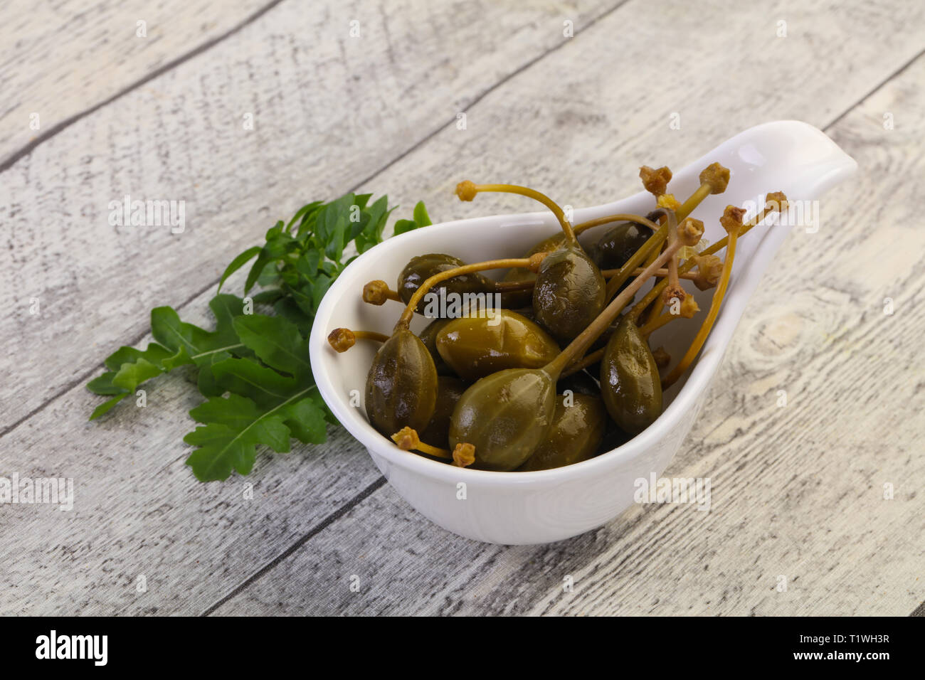 Pickled Capersberries in the bowl with basil Stock Photo - Alamy