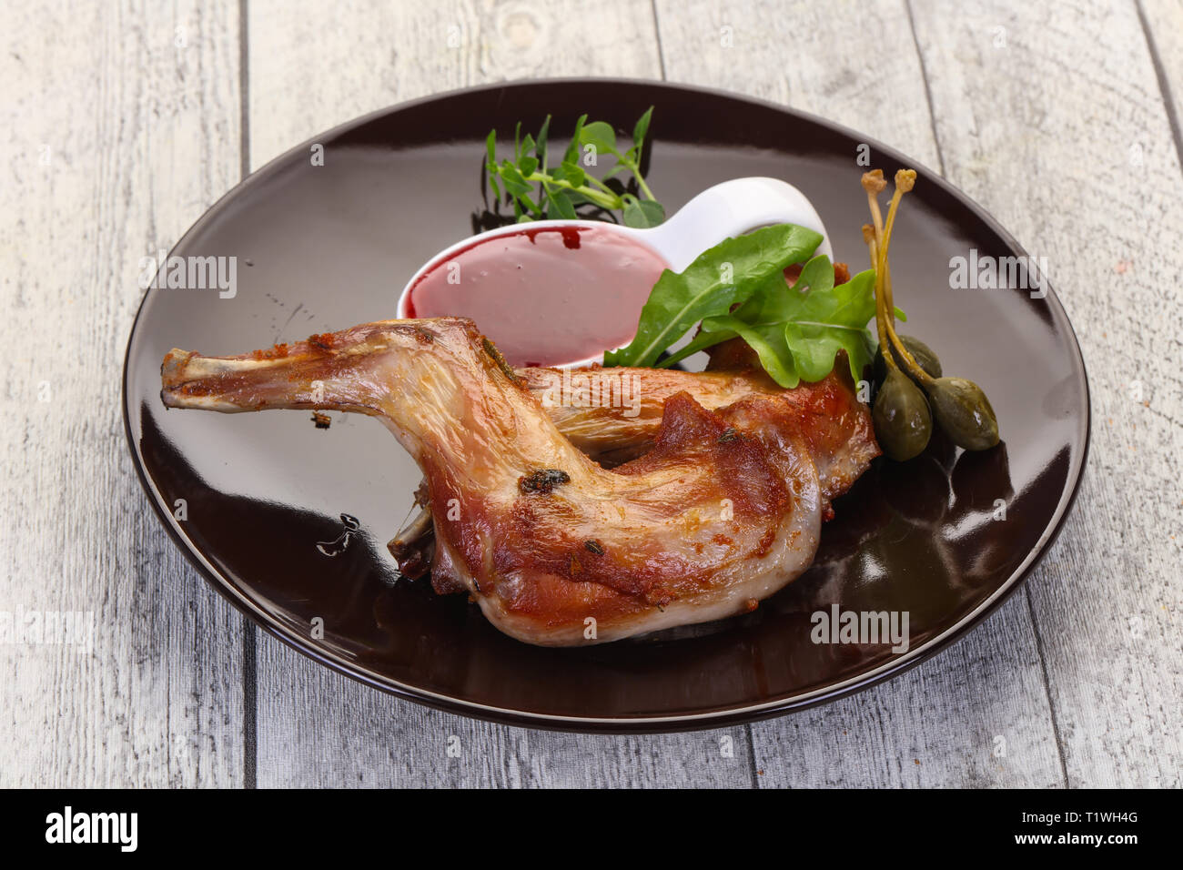 Roasted rabbit legs with cowberry sauce Stock Photo - Alamy